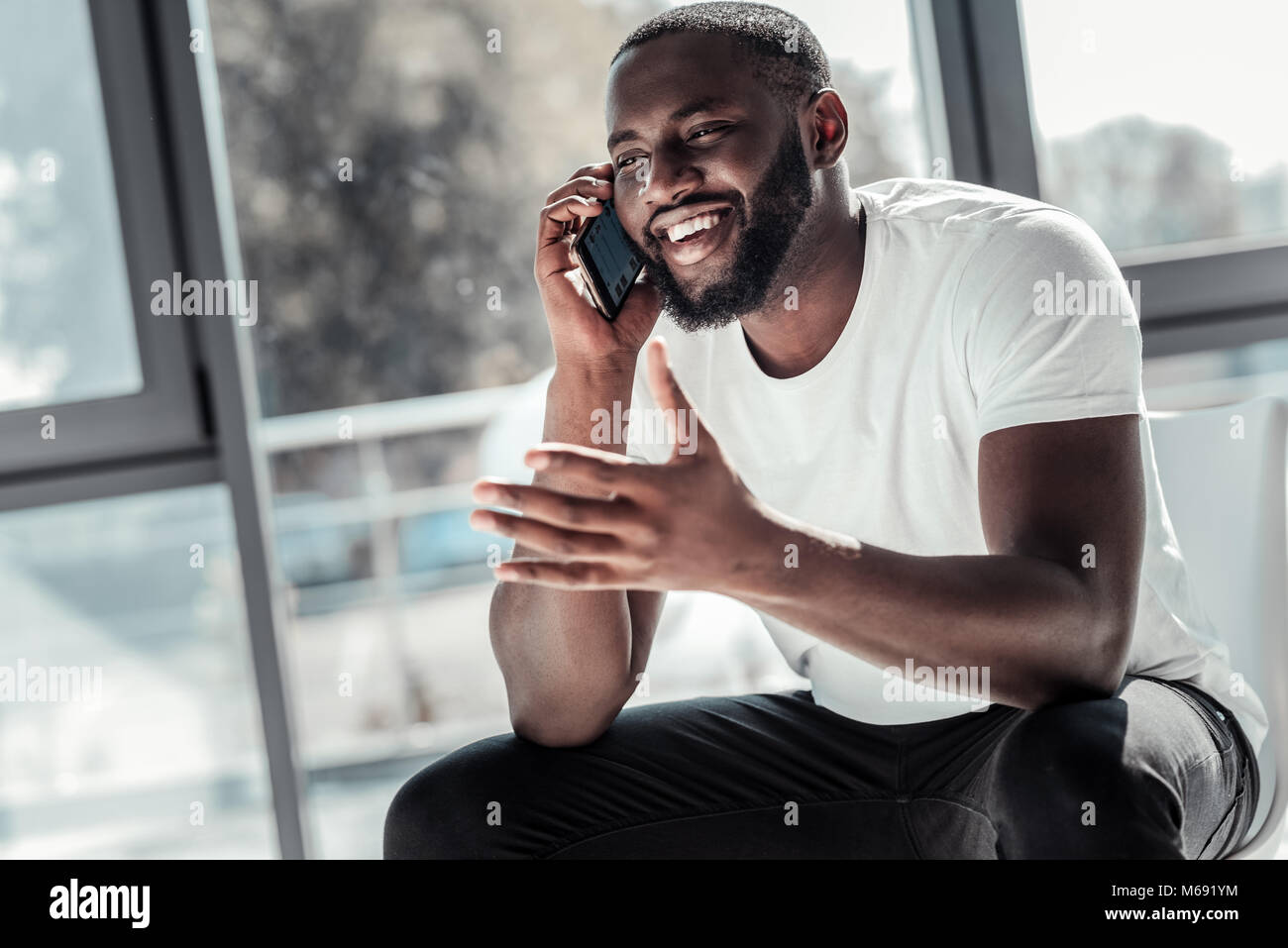 Happy cheerful man talking on the phone Stock Photo - Alamy
