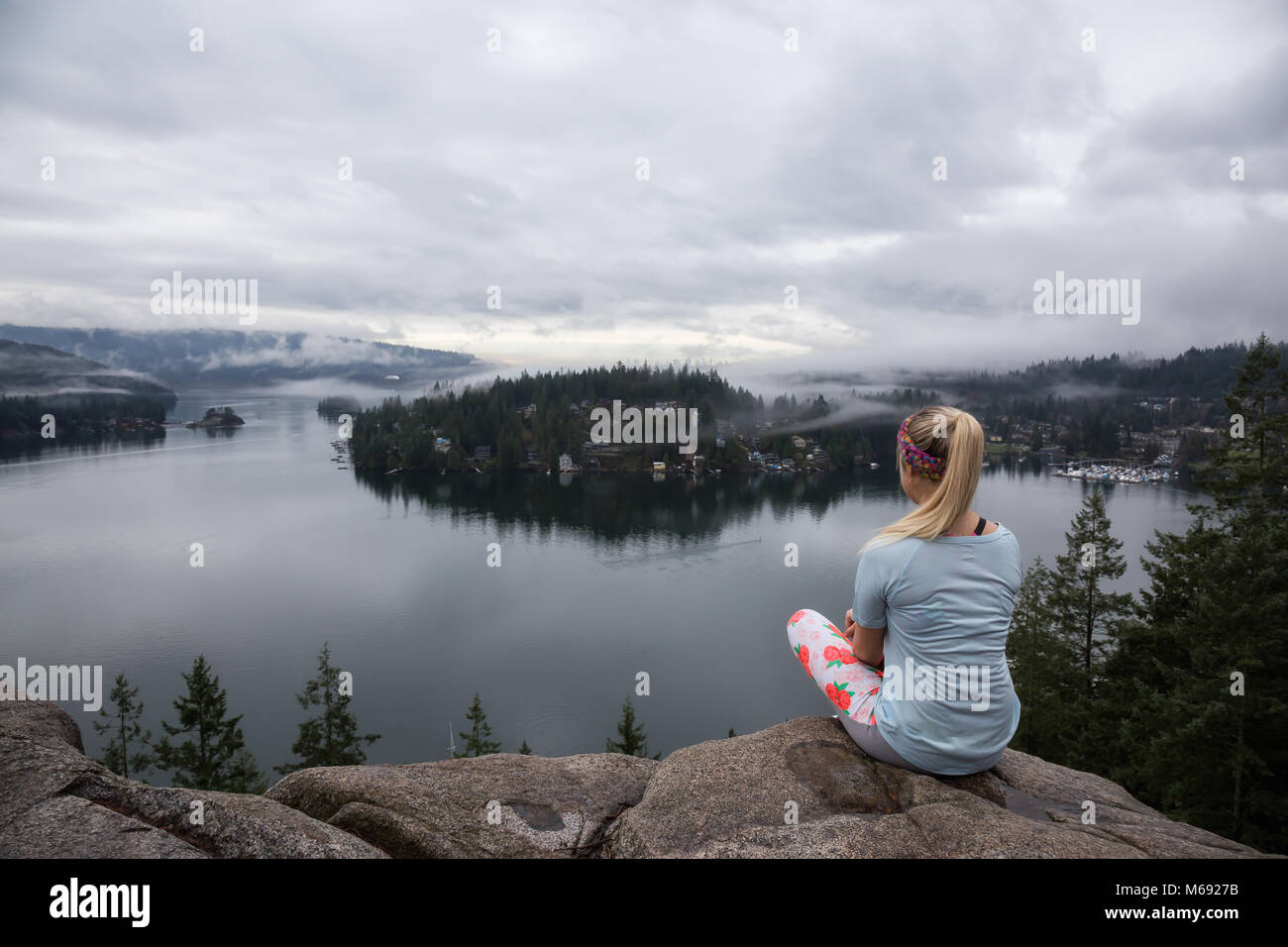 Young Caucasian Girl is enjoying a beautiful scenery from the top of a ...