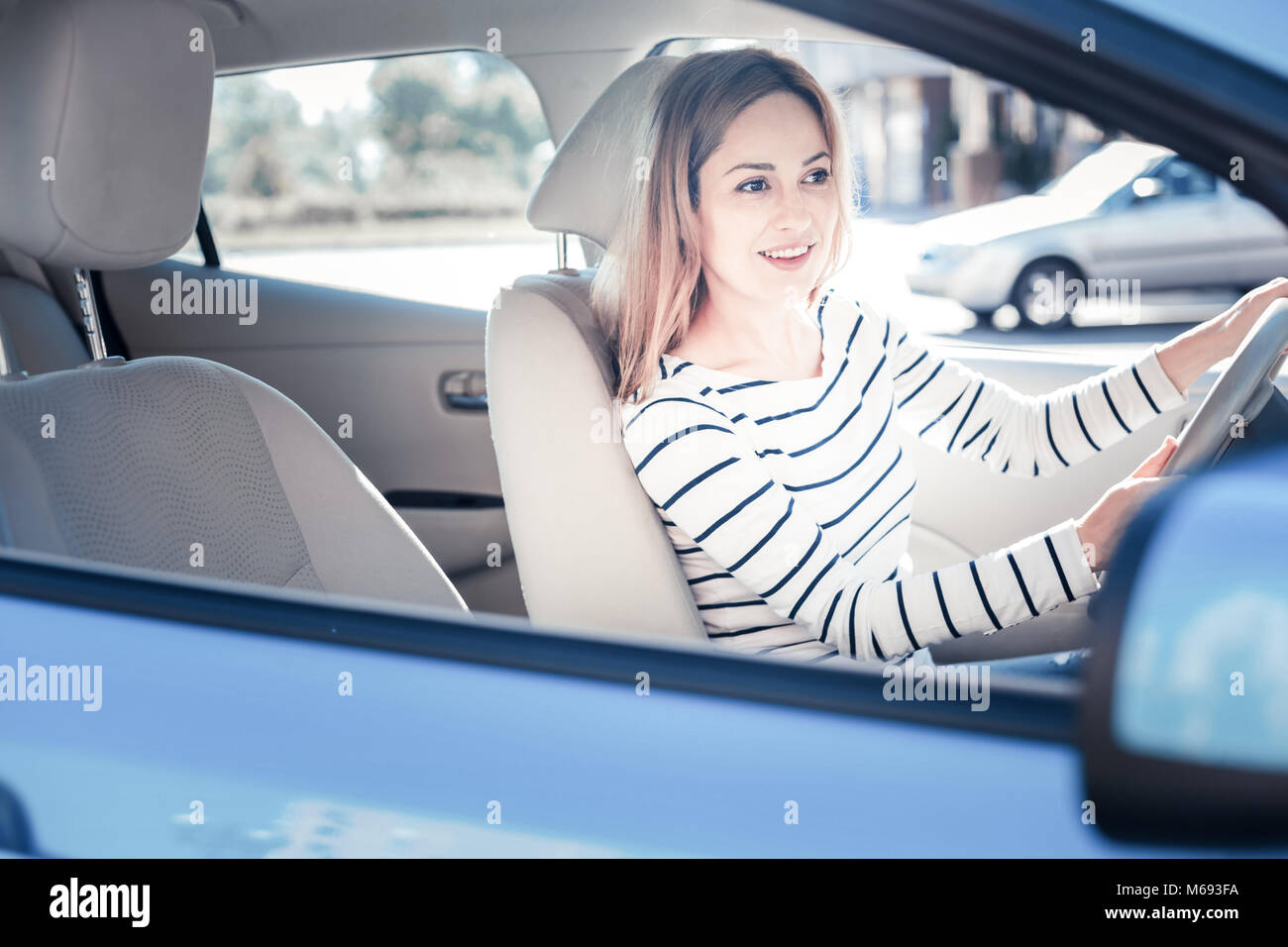 Satisfied cute woman smiling and riding in the car Stock Photo - Alamy