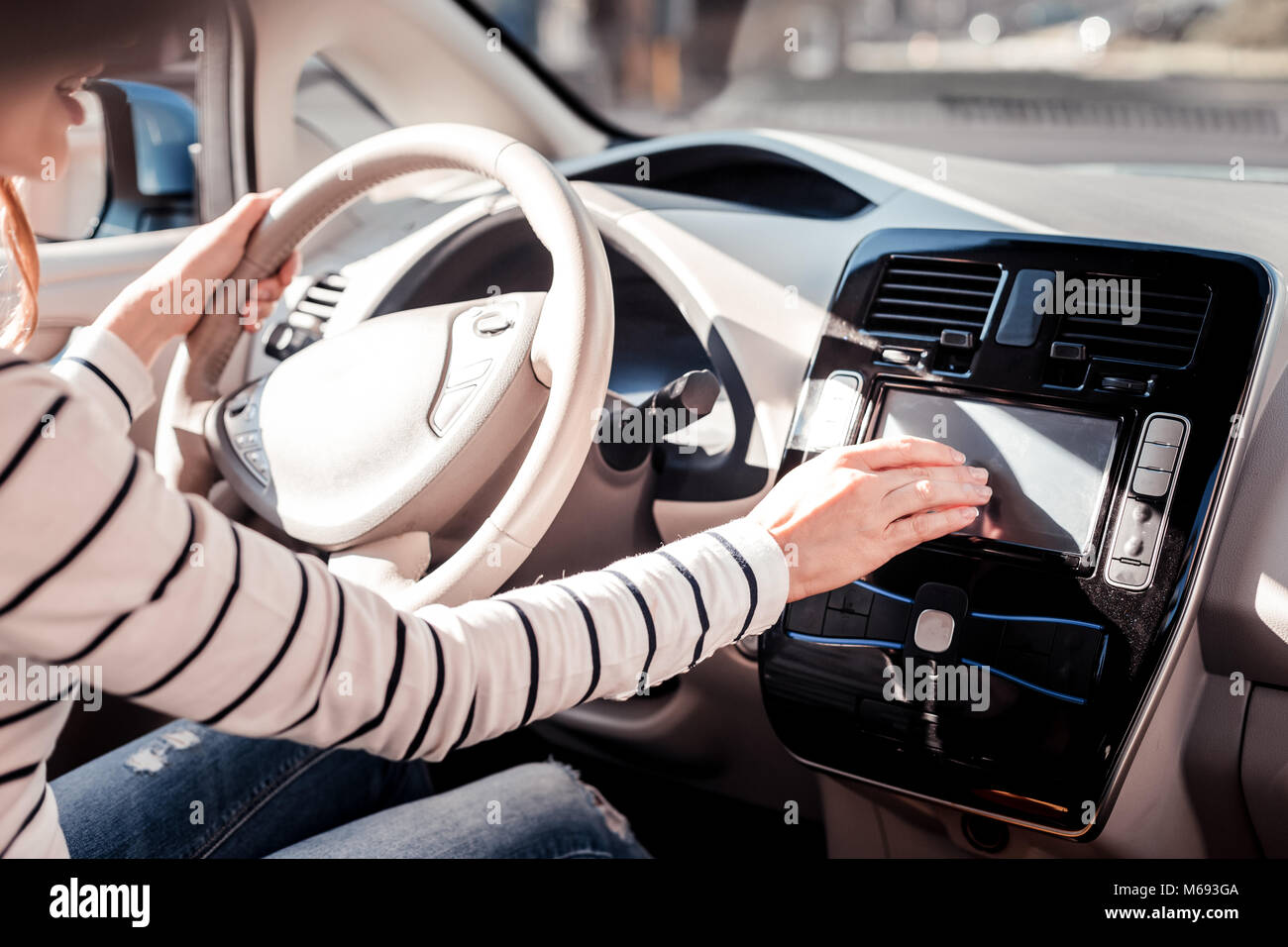 Smart careful woman sitting and setting up control panel Stock Photo ...