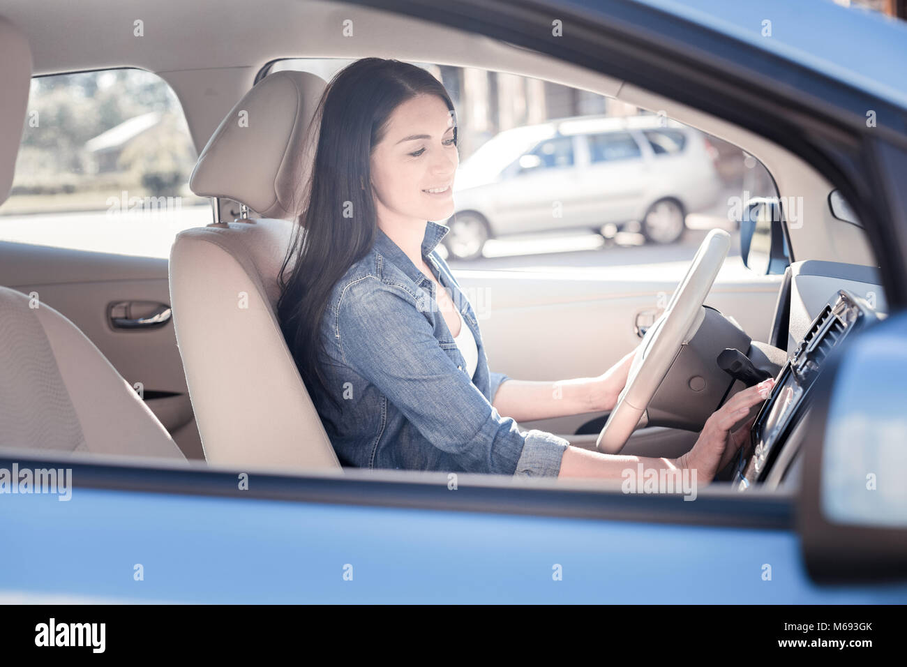 Confident pleasant woman sitting and setting up control panel Stock ...