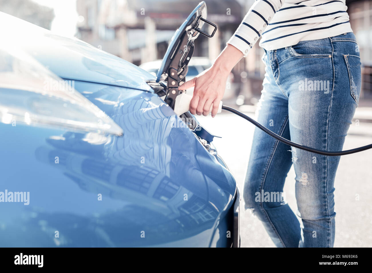 Responsible calm woman standing and using charging gadget Stock Photo ...