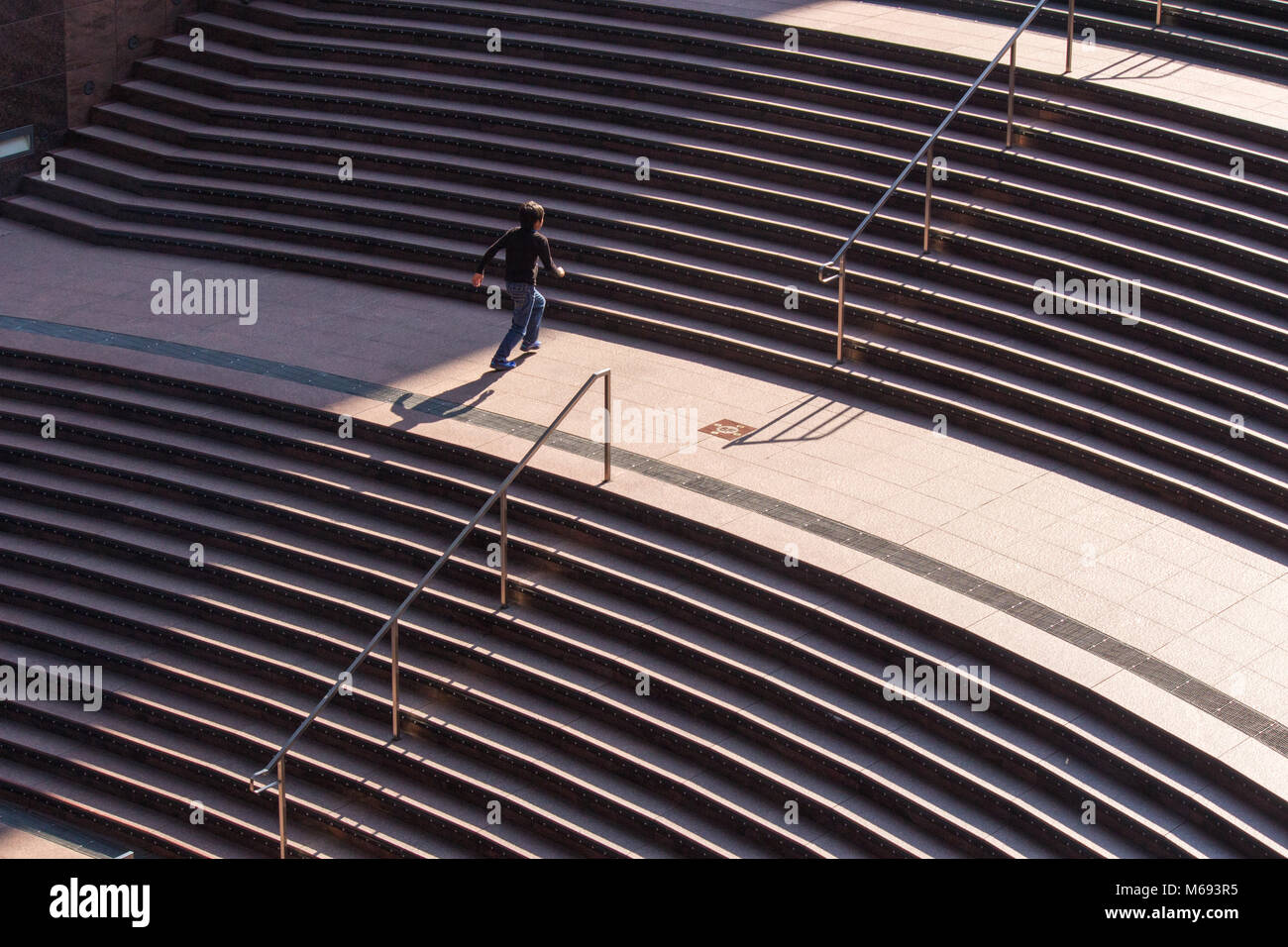 Shadows of a person on steps in the modern structure of Kyoto railway ...