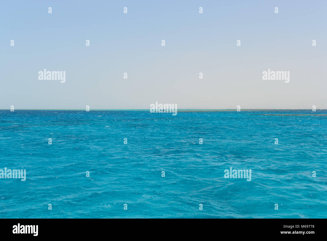 Ship on the horizon of the blue sea photo Stock Photo - Alamy