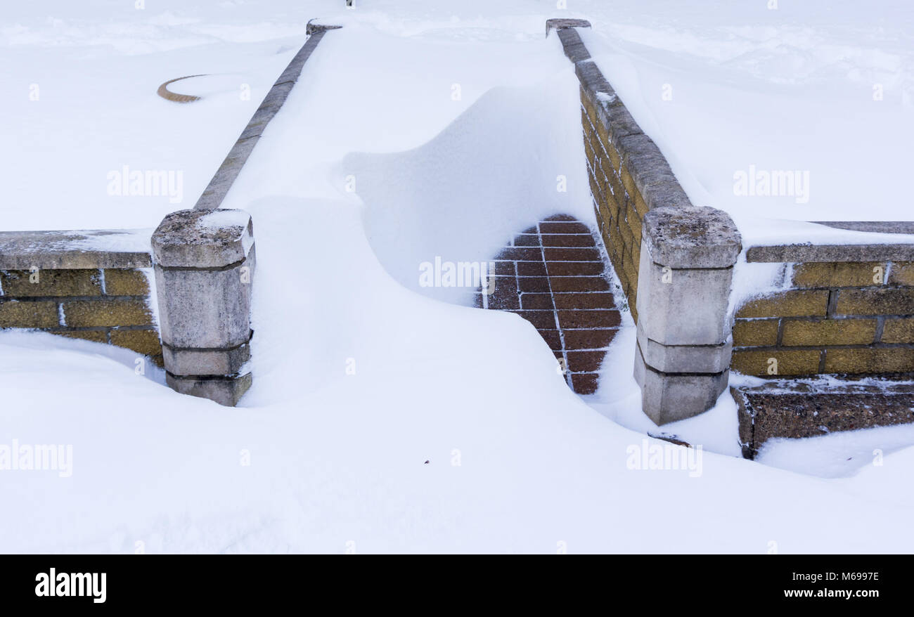 An unusual snow drift cought between boundry walls on a garden footpath ...
