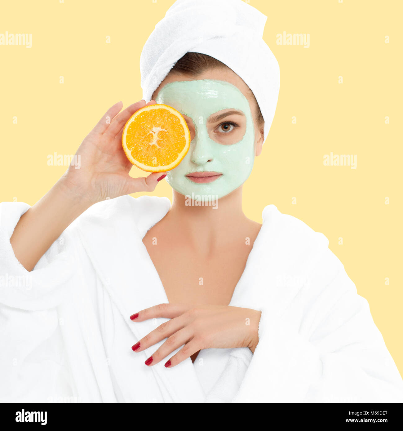 Beautiful Woman Is Getting Facial Clay Mask On Pastel Yellow Background