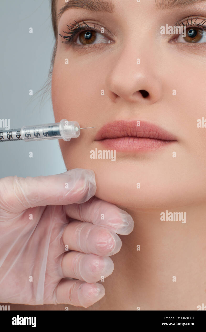 Beautiful girl receiving filler injection in lips. Cosmetic Treatment ...