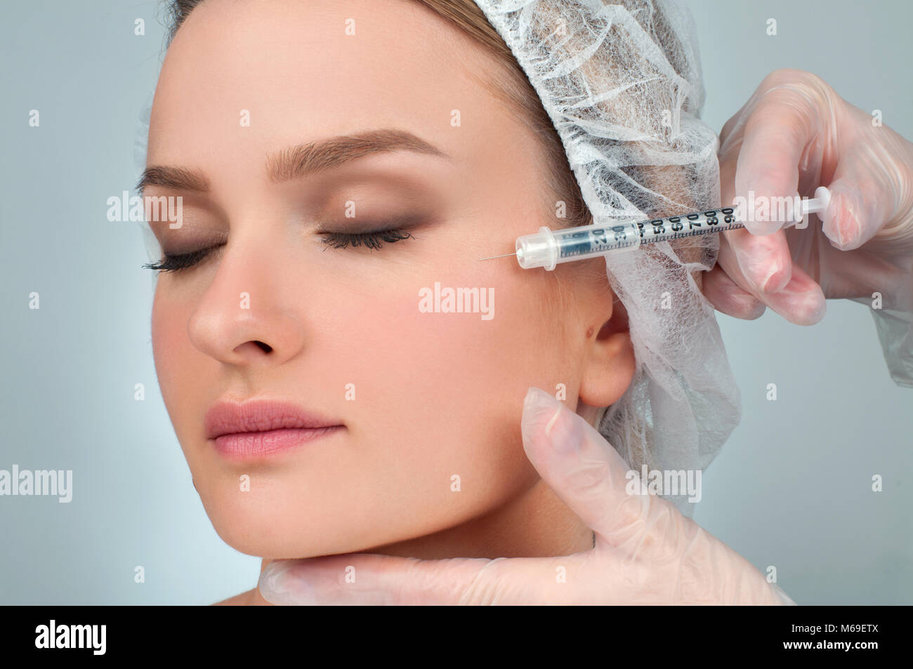 Woman is getting filler injection in cheeks. Anti-aging treatment and ...