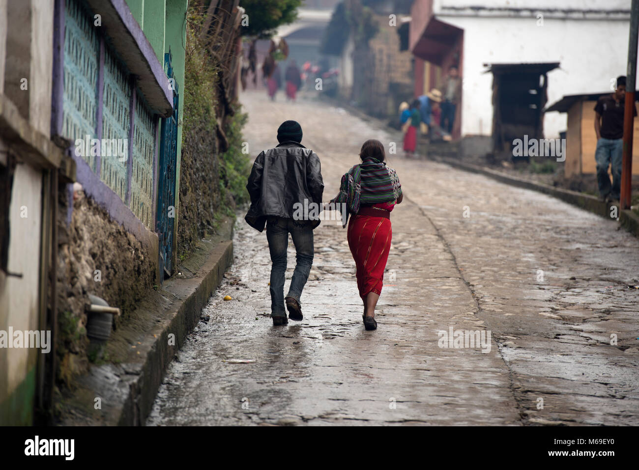 An indigenous Ixil Maya man walking, holding hands with his wife on a ...
