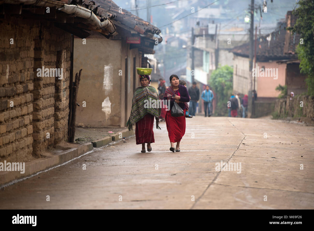 Ethnic, indigenous Ixil Maya women in traditional clothing walking home ...
