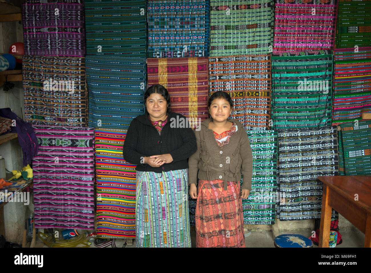 An indigenous ethnic Ixil Maya woman and her daughter selling colourful ...