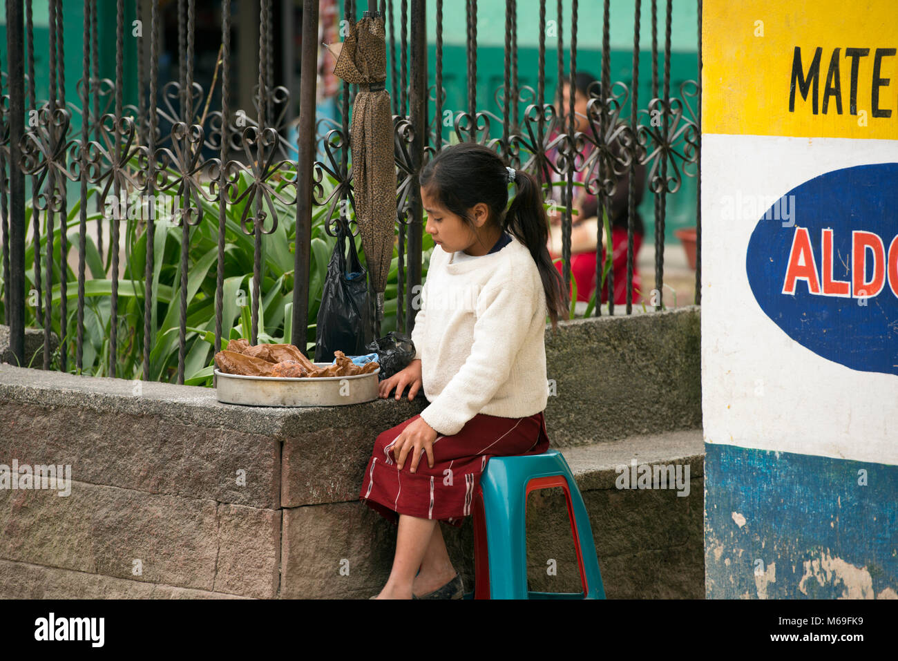 A young indigenous ethnic Ixil Maya girl selling chicken on the street ...