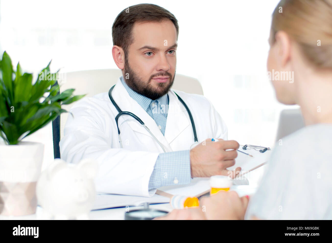 Doctor is writing prescription to patient Stock Photo - Alamy