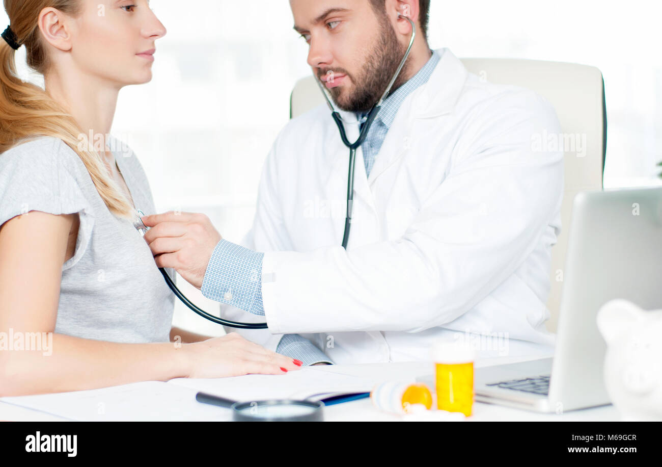 Doctor with stethoscope listening to the patient. Doctor checking heart ...