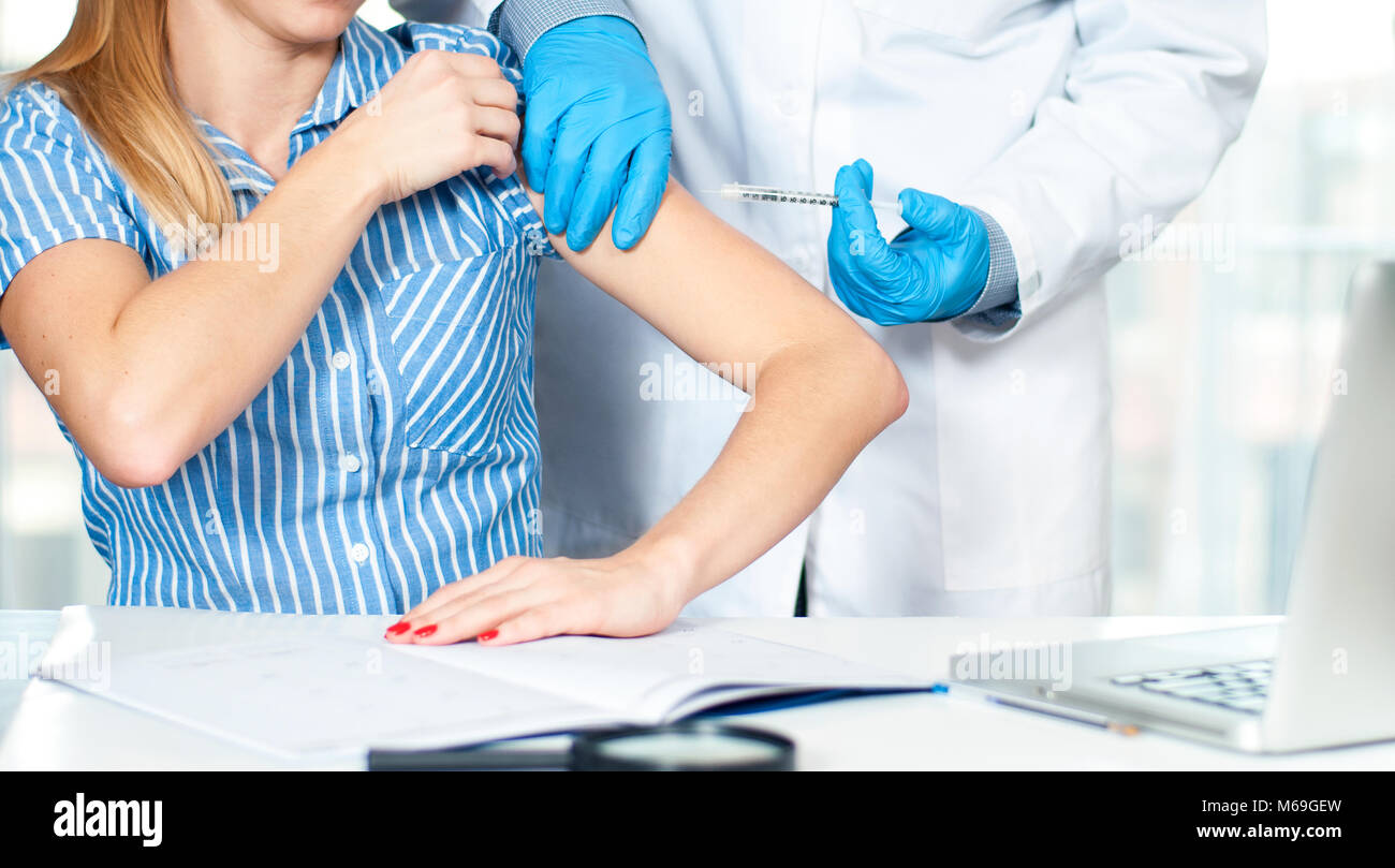 Vaccination. Flu shot. Doctor with syringe making vaccination to ...
