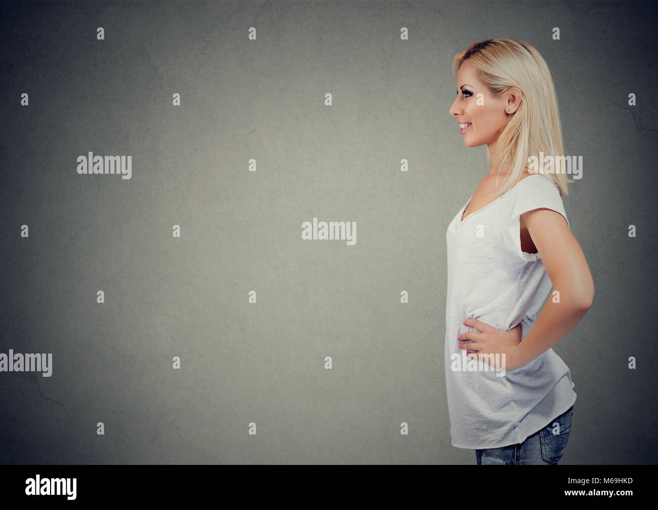 Side view of casual middle-aged blonde standing confidently with hands ...