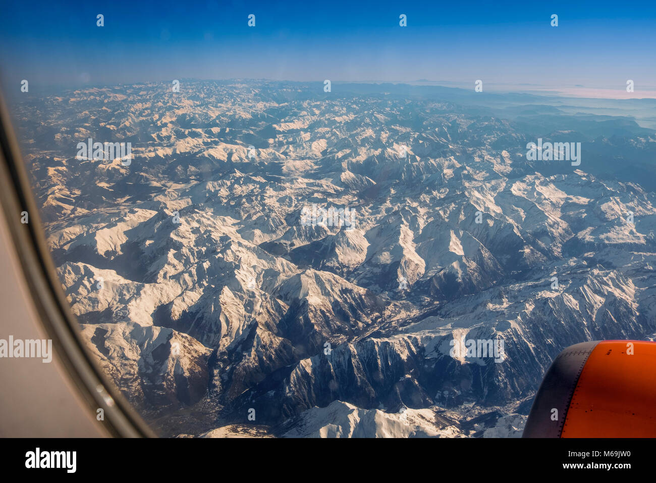 View from a passenger plane, alpine mountain peaks of the Swiss Alps in ...