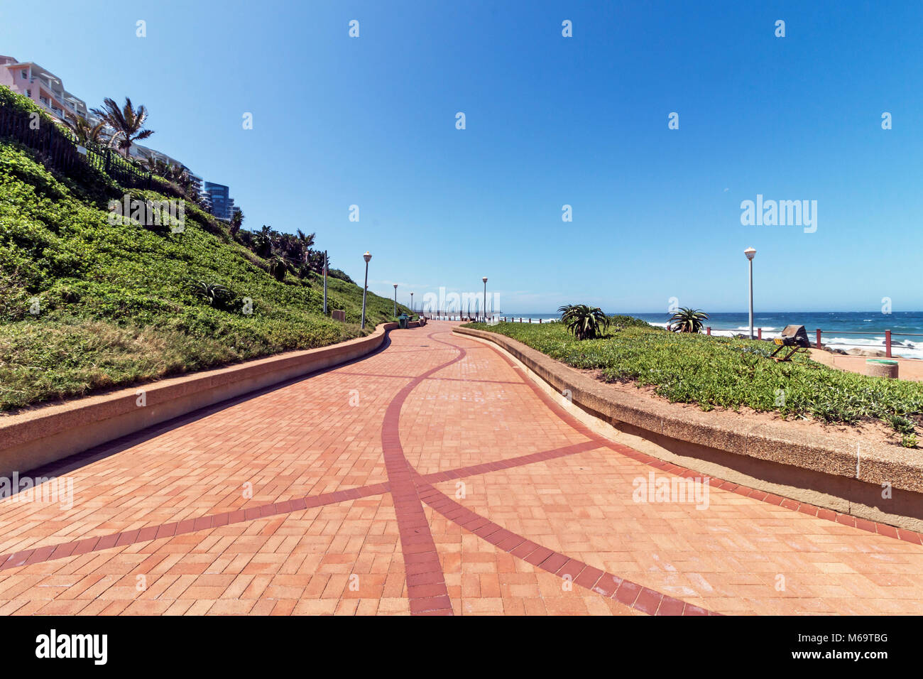 Green vegetation lined paved and patterned promenade coastal seascape ...