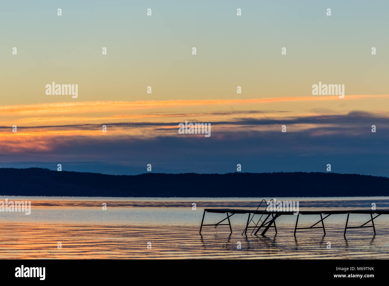 Long jetty with ladder in lake at sunrise Stock Photo - Alamy