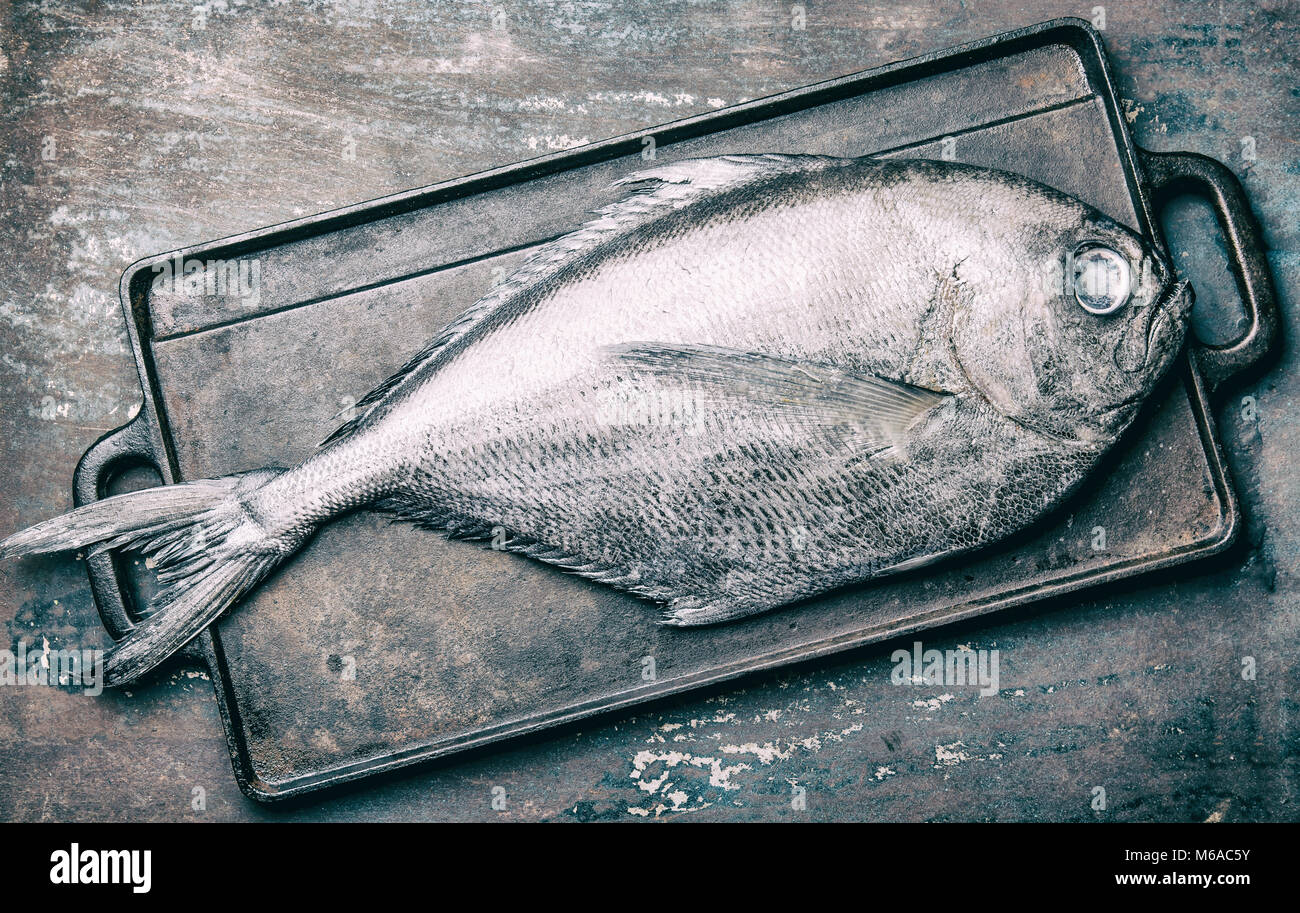 Food background with raw fresh fish reineta, herbs, olil and lemon. Top ...