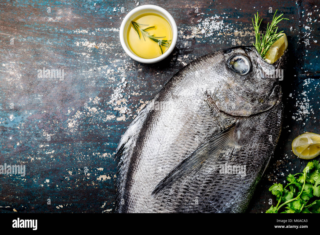 Food background with raw fresh fish reineta, herbs, olil and lemon. Top ...