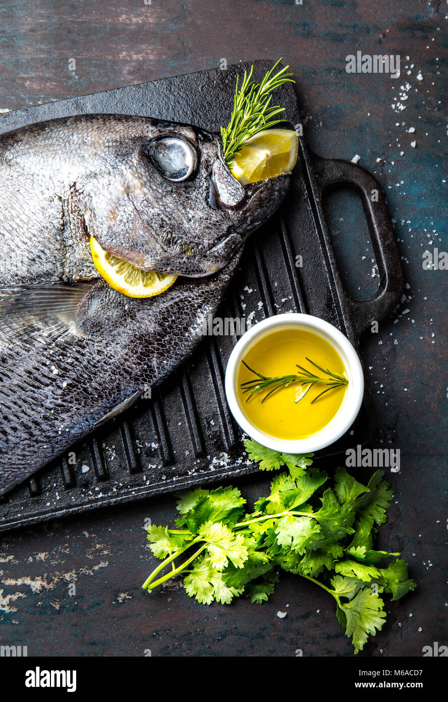 Food background with raw fresh fish reineta, herbs, olil and lemon. Top ...