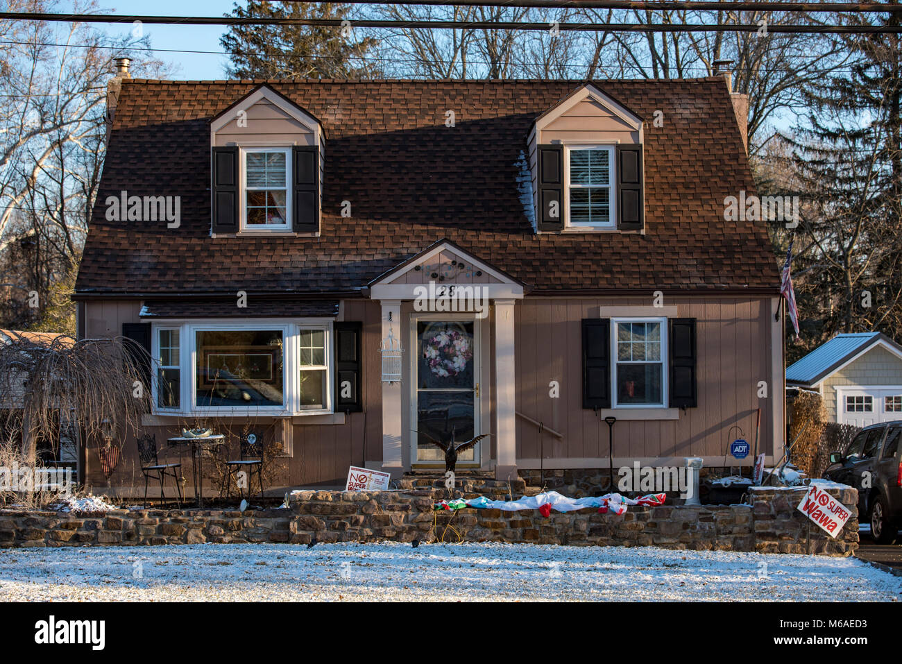 Photograph of Suburban home exteriours with sky and treeline visible ...