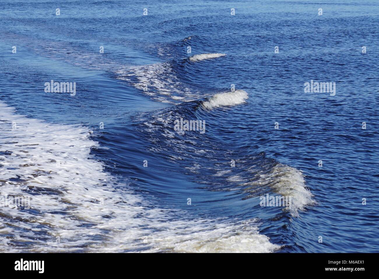 Patterns of waves in water, in the wake behind a boat Stock Photo - Alamy