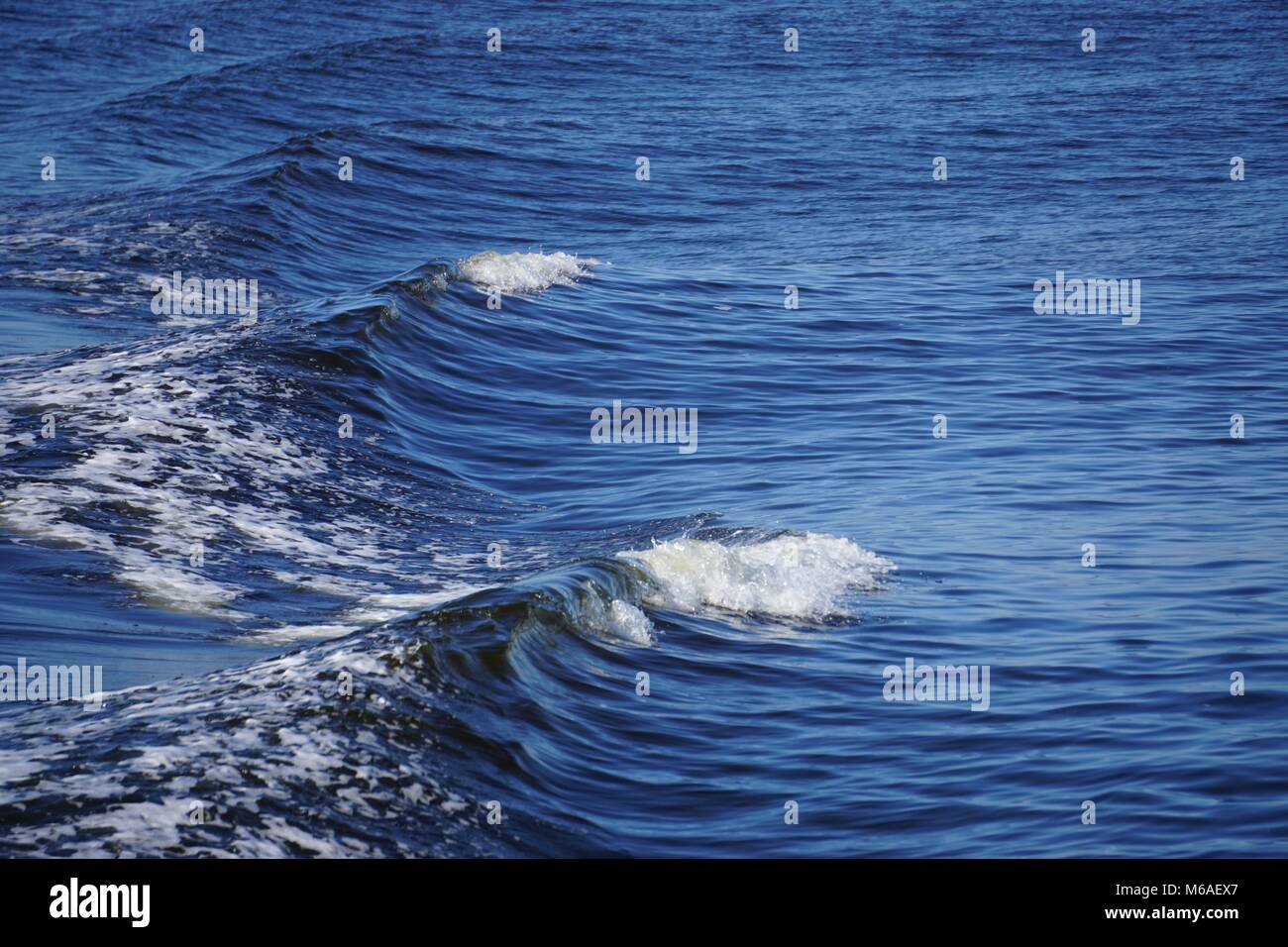 Patterns of waves in water, in the wake behind a boat Stock Photo - Alamy