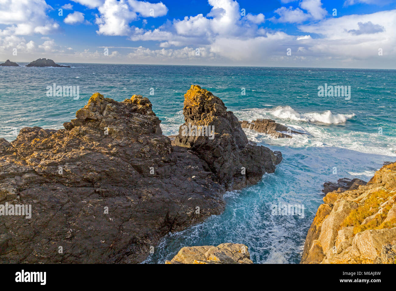Jagged granite rocks at Cape Cornwall with the Brisons rocks beyond ...