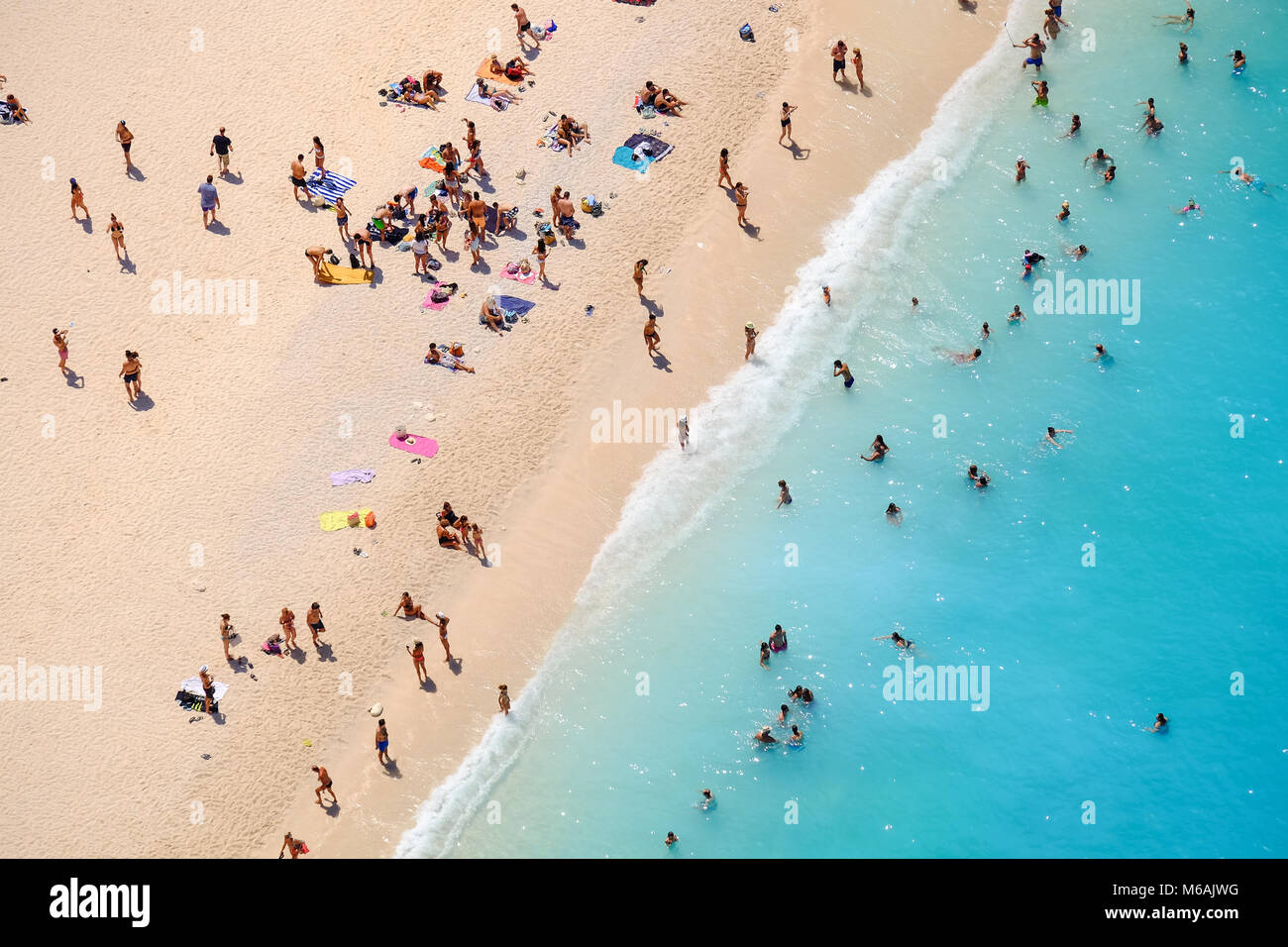 People bathing in the sun, swiming and playing games on the beach ...