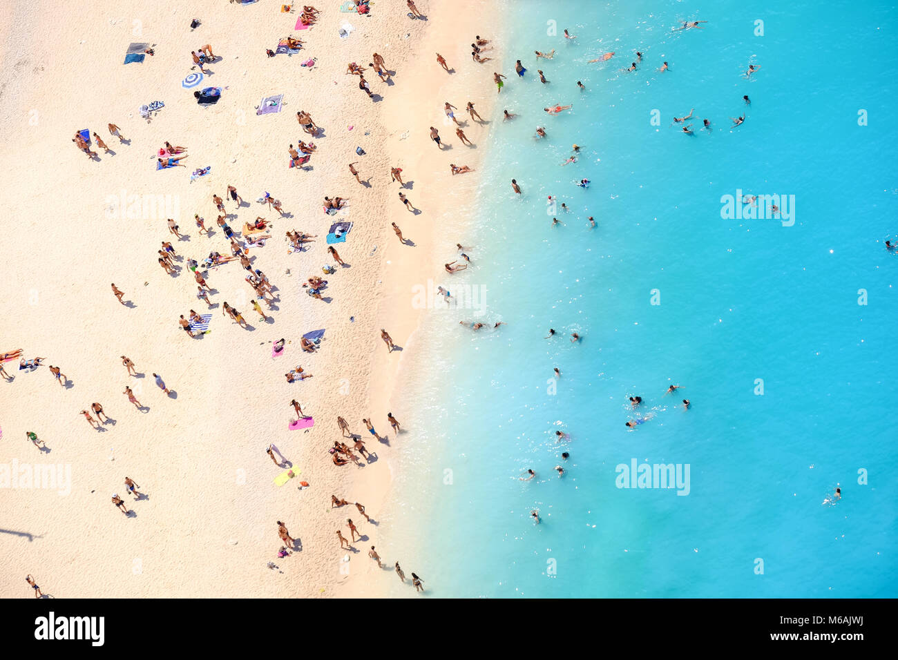 People bathing in the sun, swiming and playing games on the beach ...