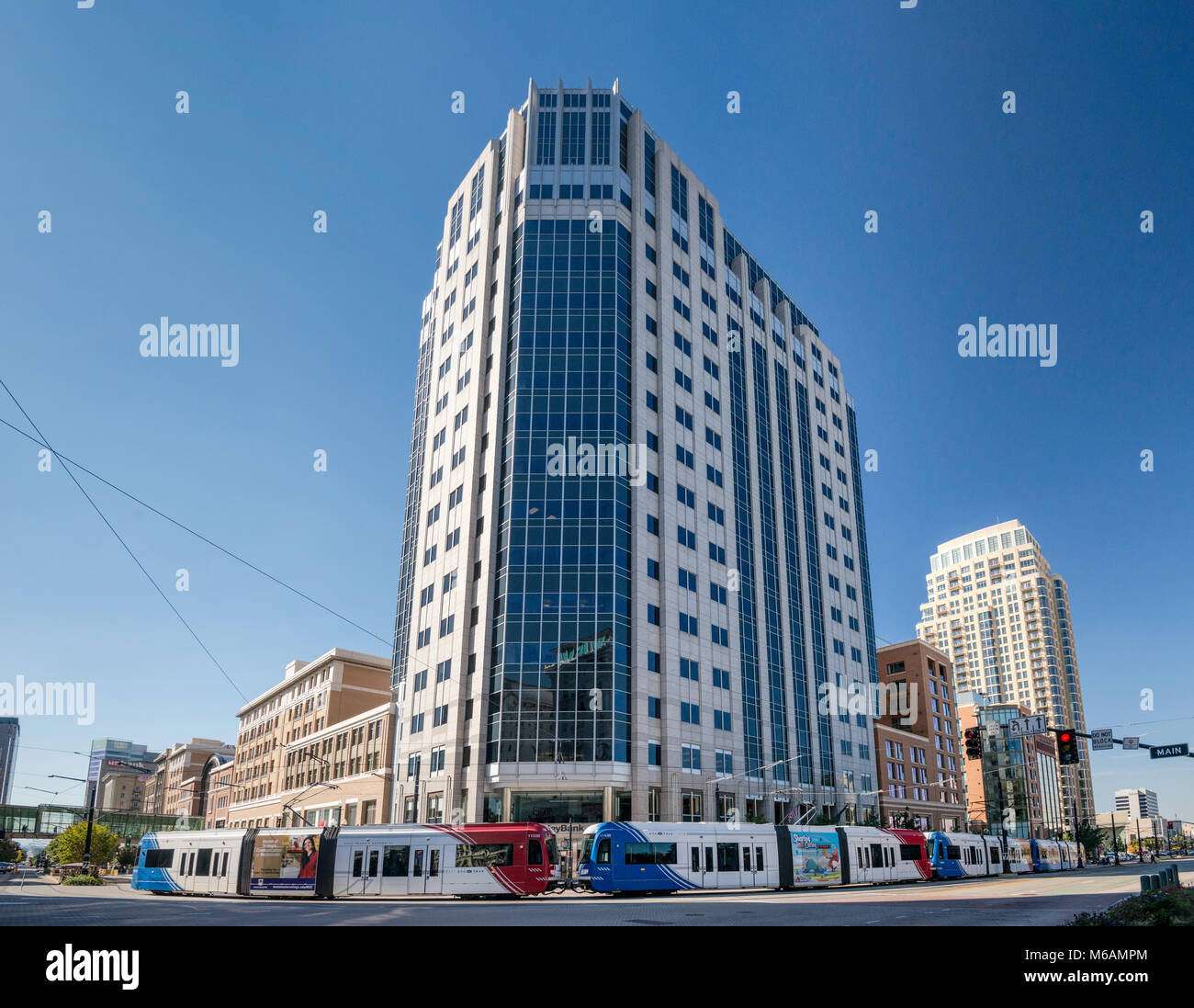 Office towers, TRAX light rail train on South Temple Street turning ...