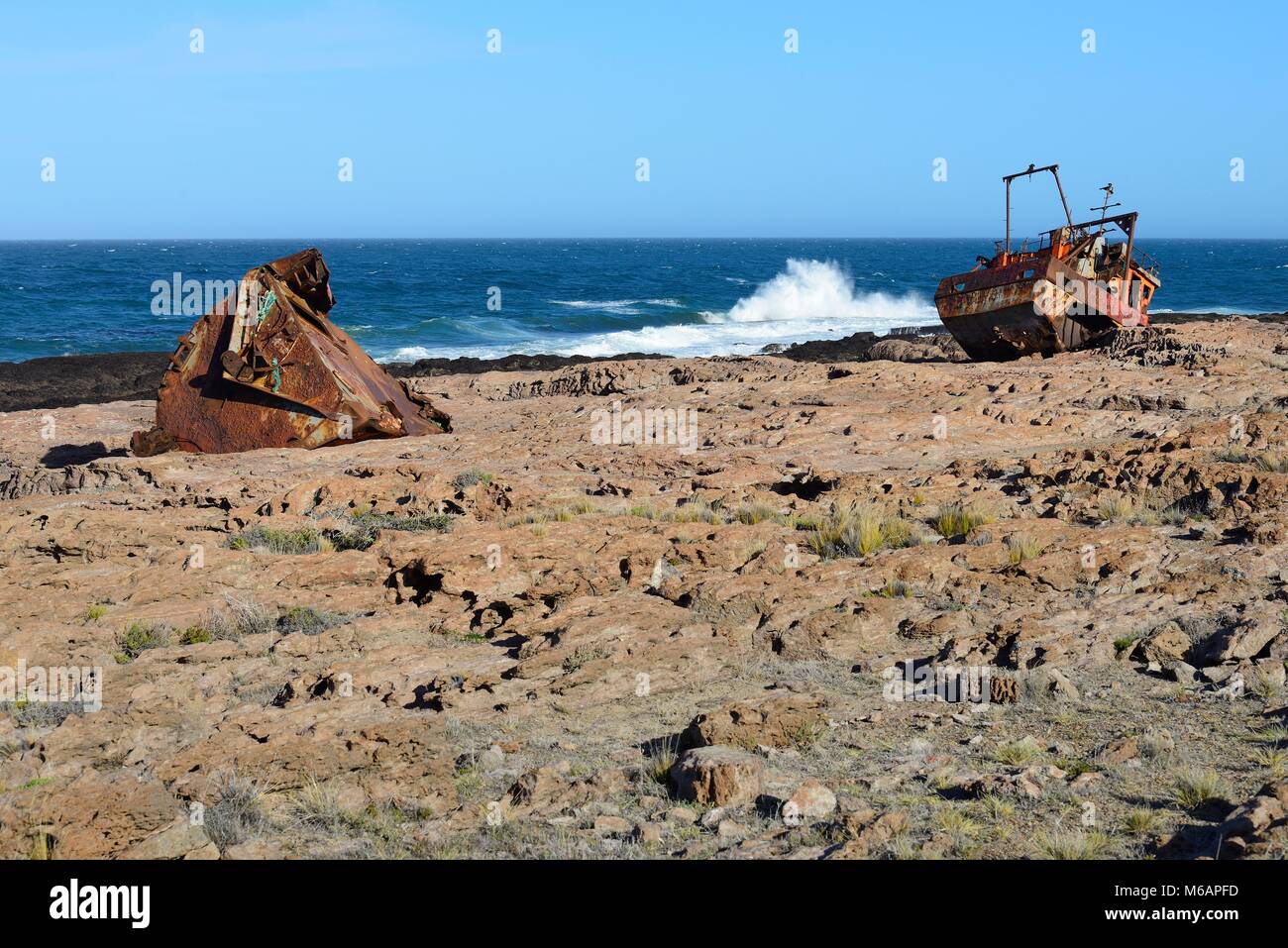 Rusty wreck of a fish trawler on the rocky shore, Cabo Raso, near ...