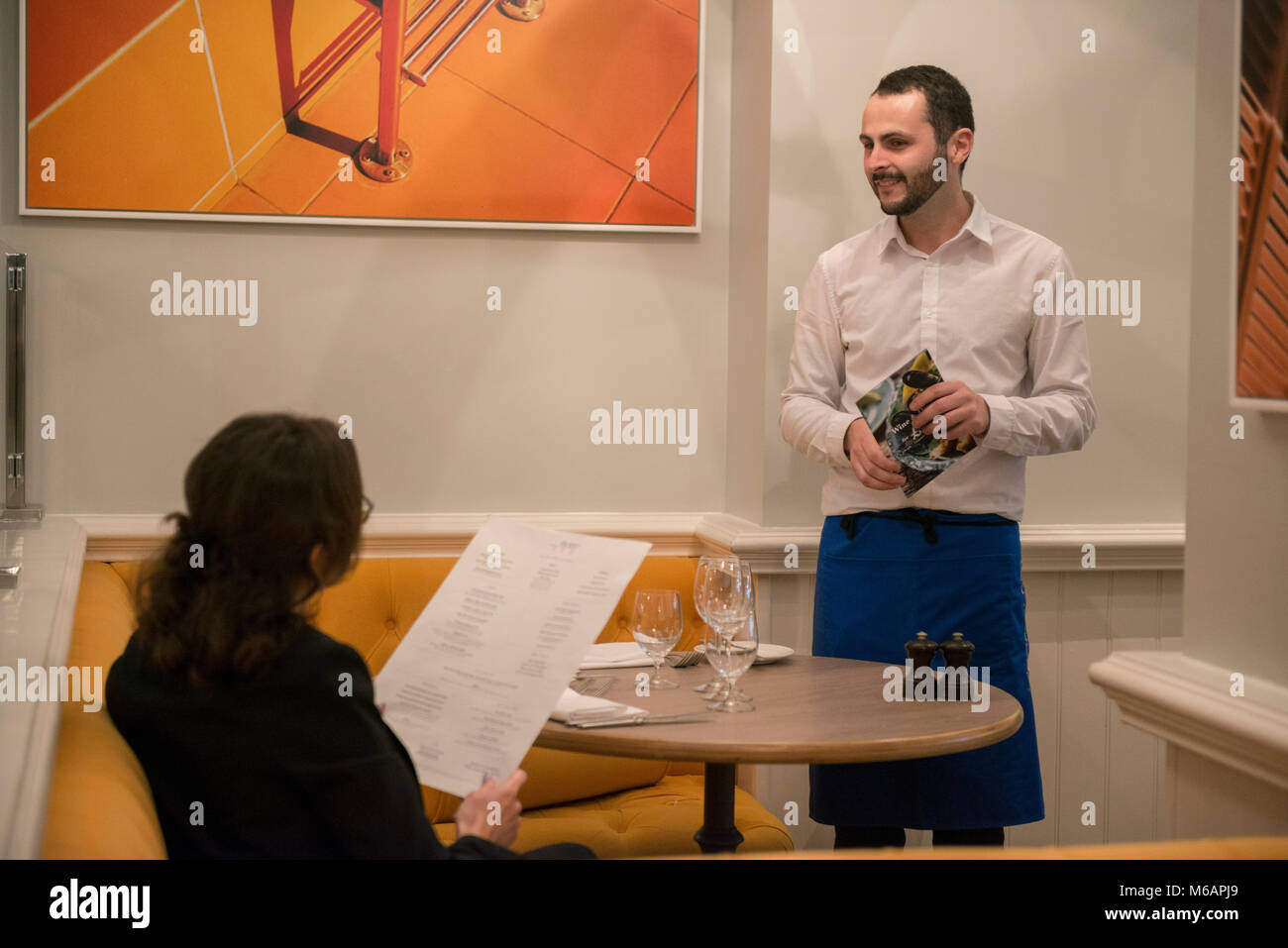 a male waiting staff working at a restaurant Stock Photo - Alamy