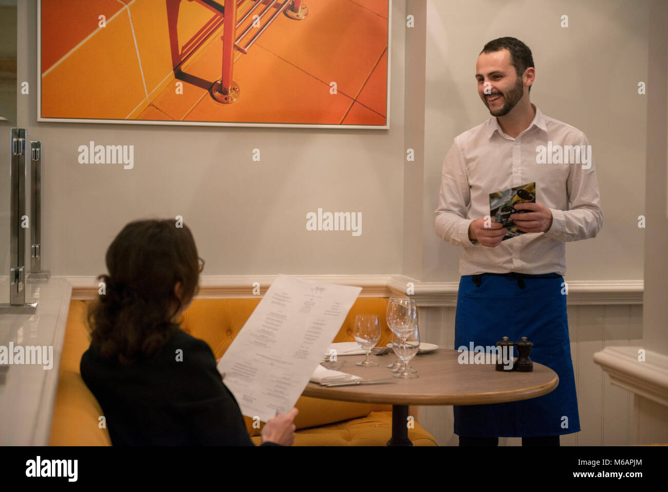 a male waiting staff working at a restaurant Stock Photo - Alamy