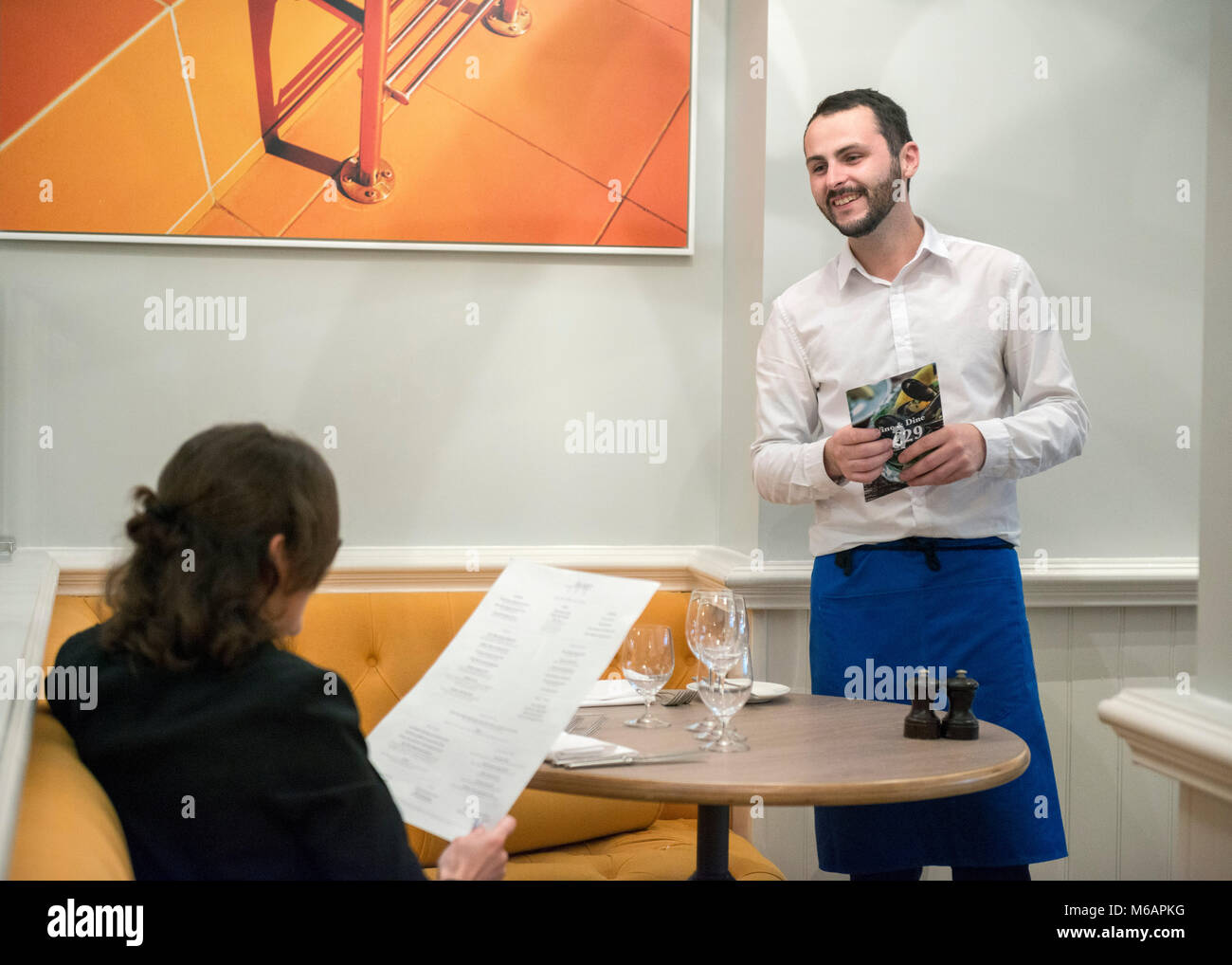 a male waiting staff working at a restaurant Stock Photo - Alamy