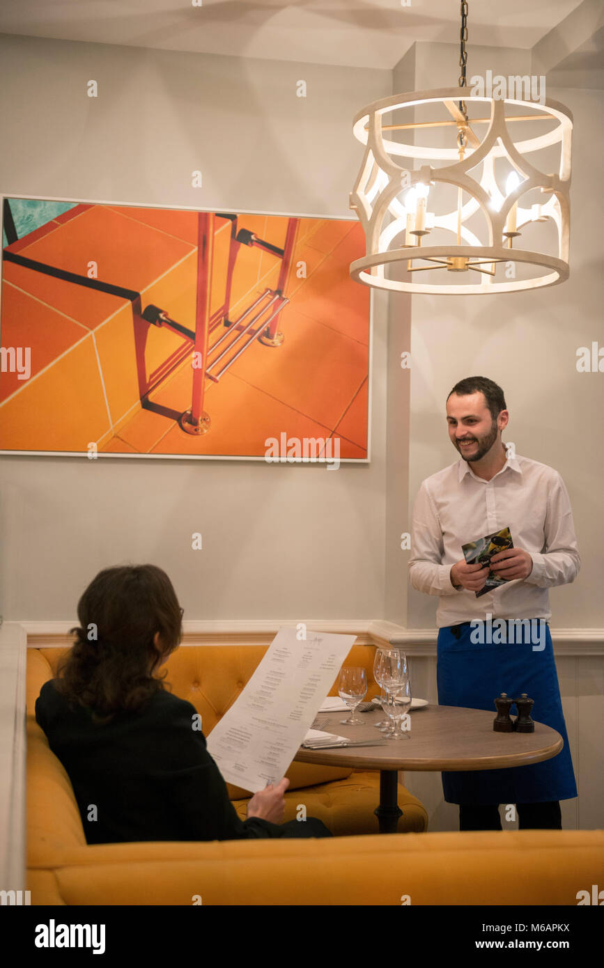 a male waiting staff working at a restaurant Stock Photo - Alamy