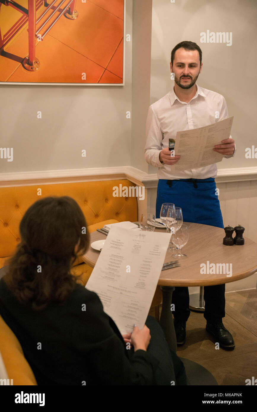 a male waiting staff working at a restaurant Stock Photo - Alamy