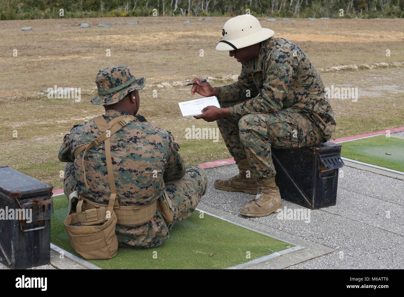 CAMP SCHWAB, OKINAWA, Japan – A range coach gives a Marine advice about ...