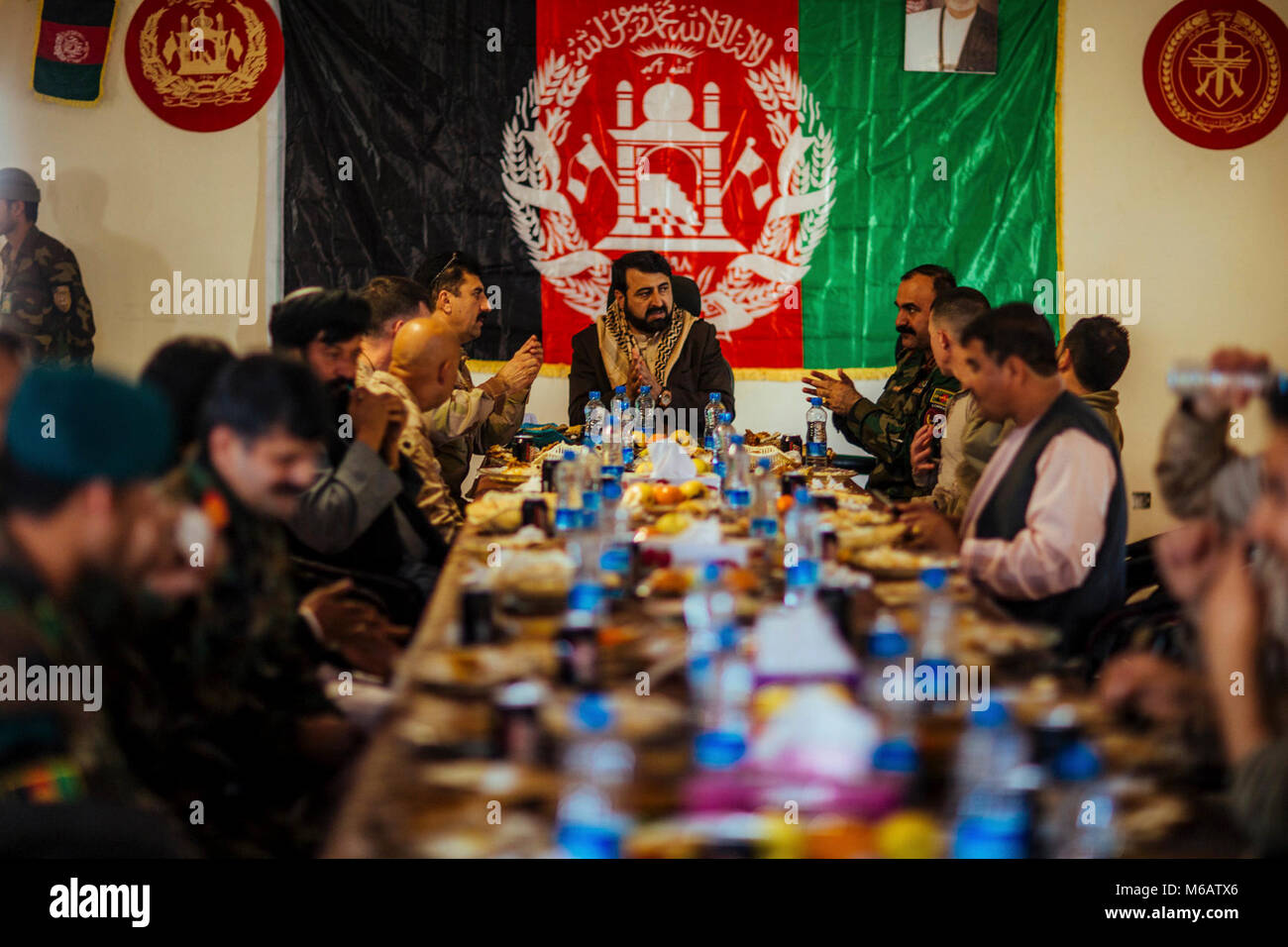 Mr. Hayatullah Hayat, governor of Helmand province, shares a meal with ...