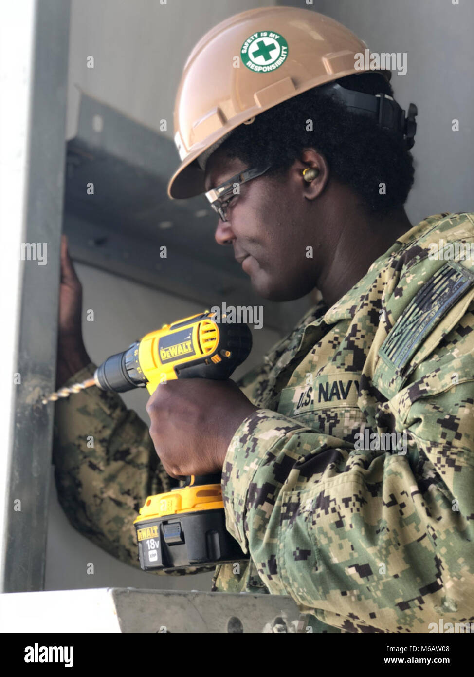 Utilitiesman 3rd Class LaToya Graham drills bolt sized holes to install ...