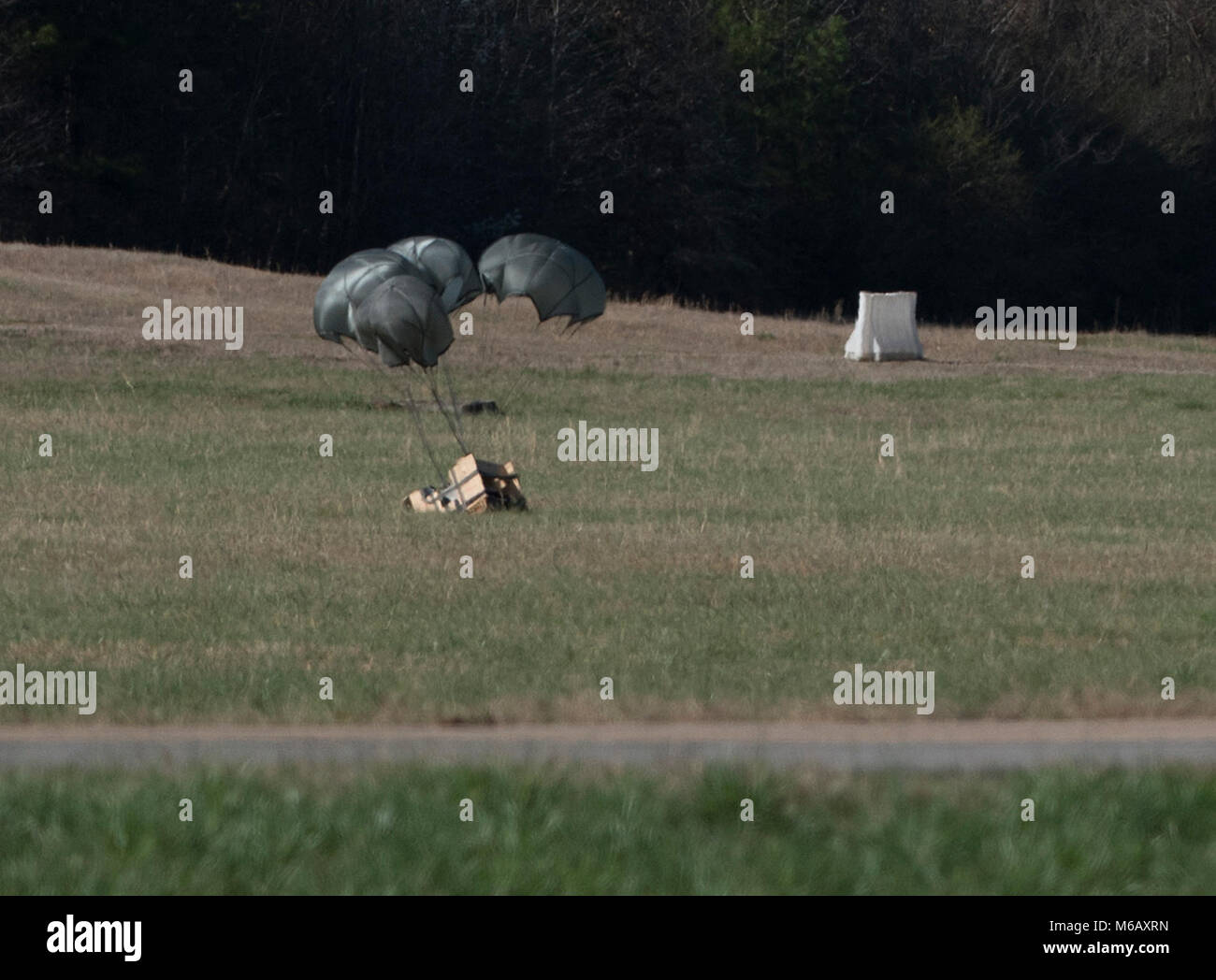 Parachutes deliver a crate carrying an autonomous vehicle to a training ...