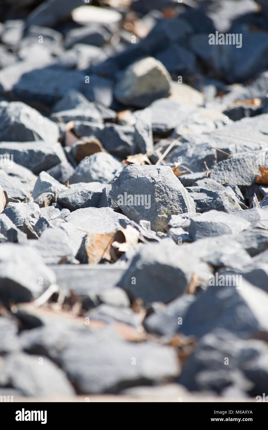 Close up of sharp, gray gravel rocks and leaves Stock Photo - Alamy