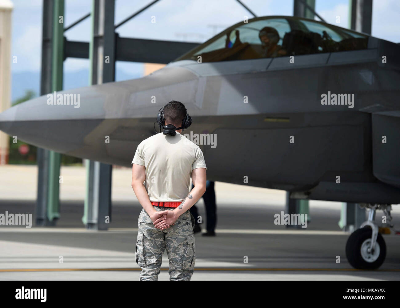 A crew chief gives a signal to an F-22 Raptor February 21, 2018, at ...
