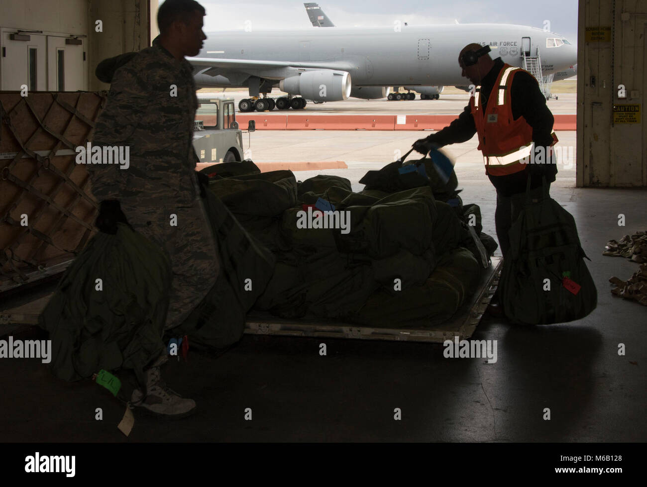 Airmen with the 60th Aerial Port Squadron, load mobility gear bags into ...