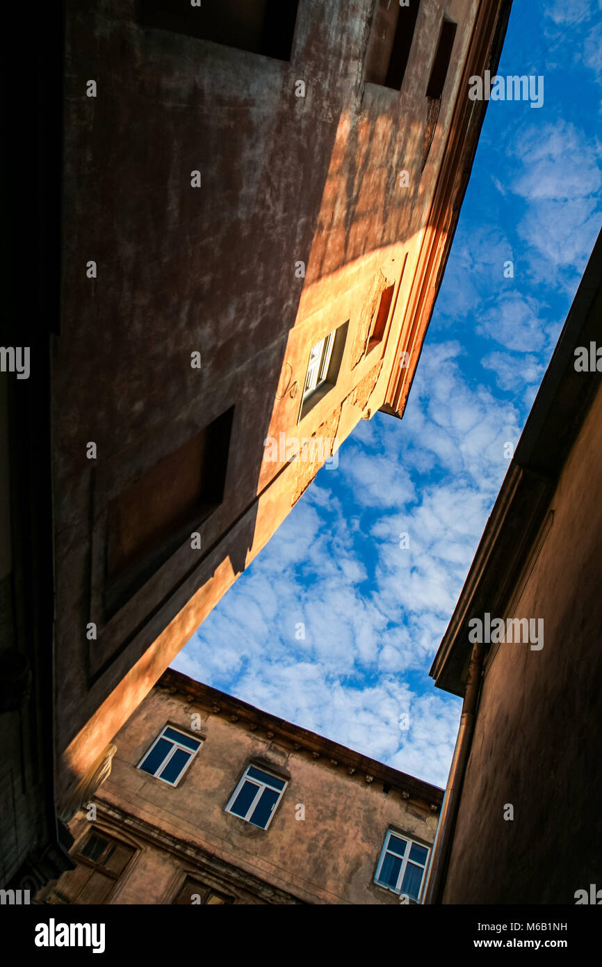 silhouettes of age-old houses under sun and shadow from downward ...