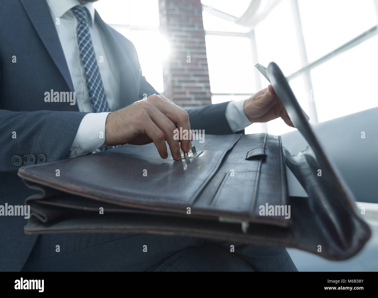 businessman's hand with suitecase in a modern office Stock Photo - Alamy