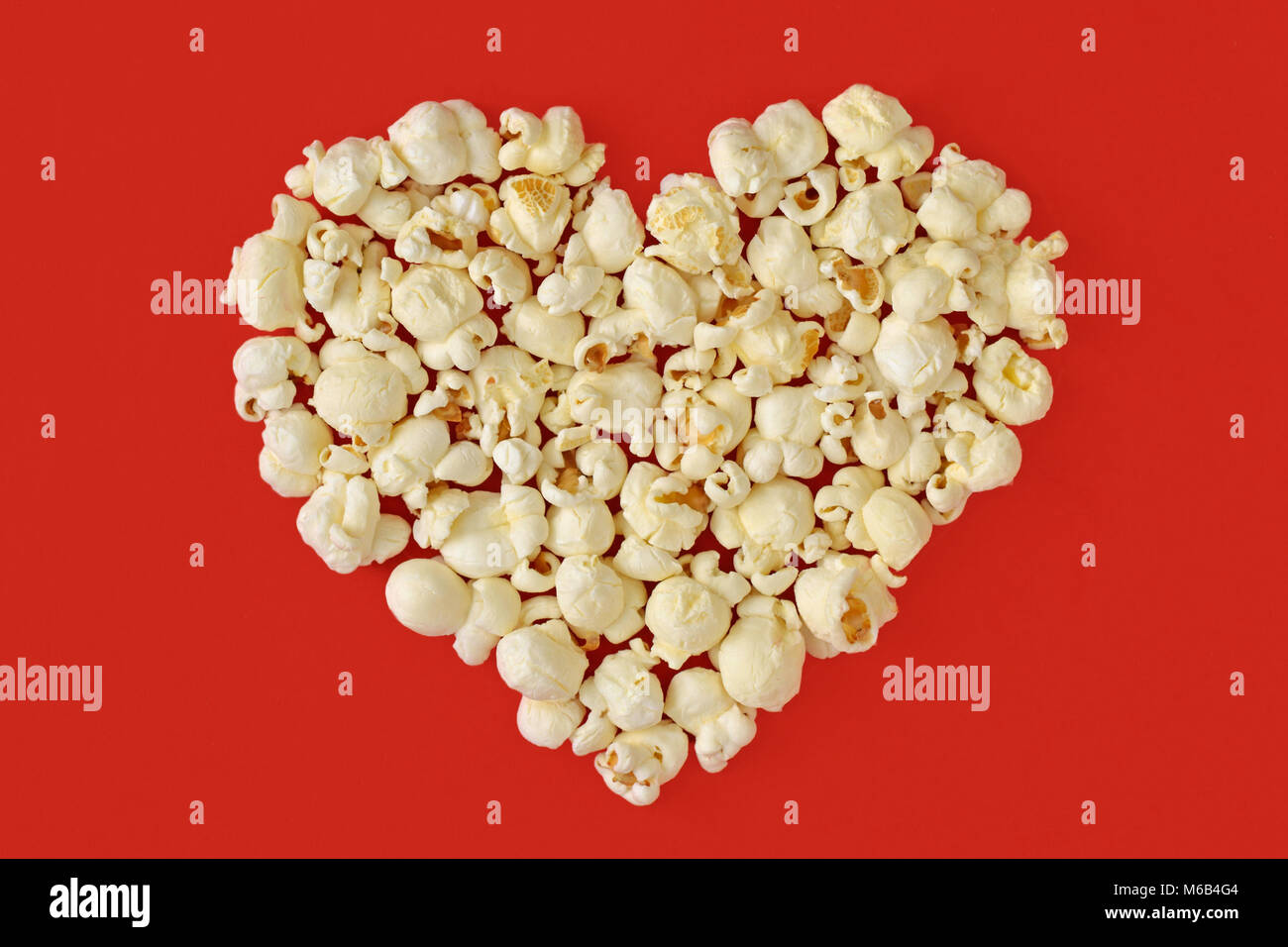 Pop corn heart on red background Stock Photo - Alamy