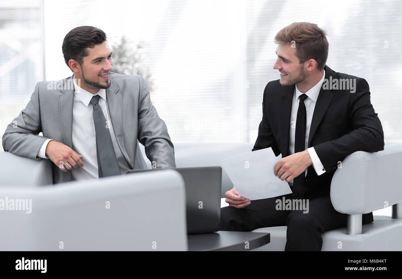 employees talking, sitting the lobby of the office Stock Photo - Alamy